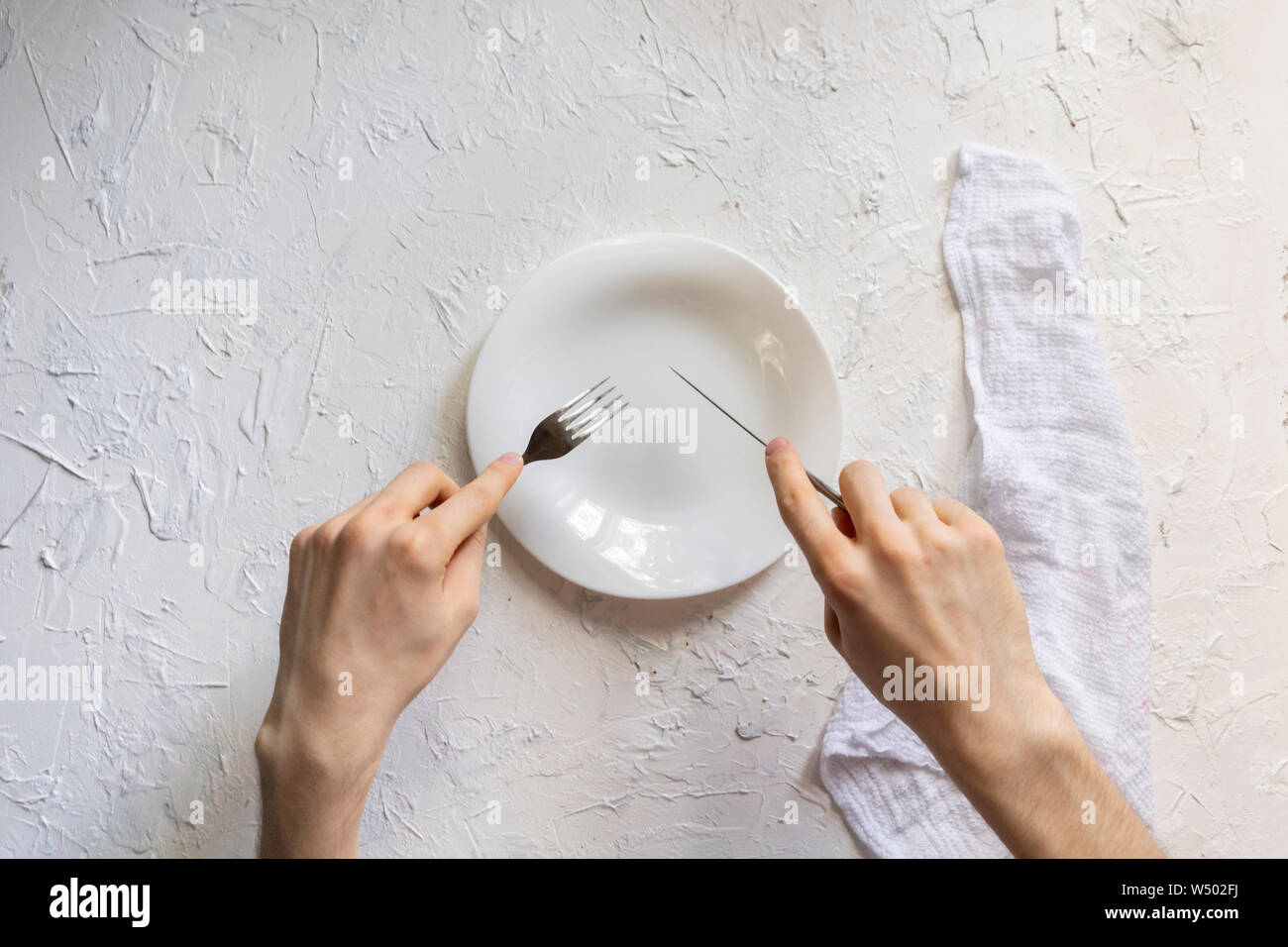 top view of person's hands on the table with empty plate design mock up ...