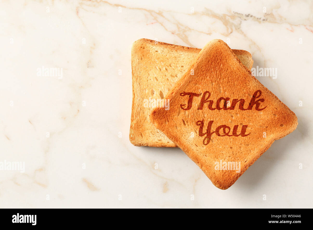 Toasted bread with inscription THANK YOU on light background Stock ...