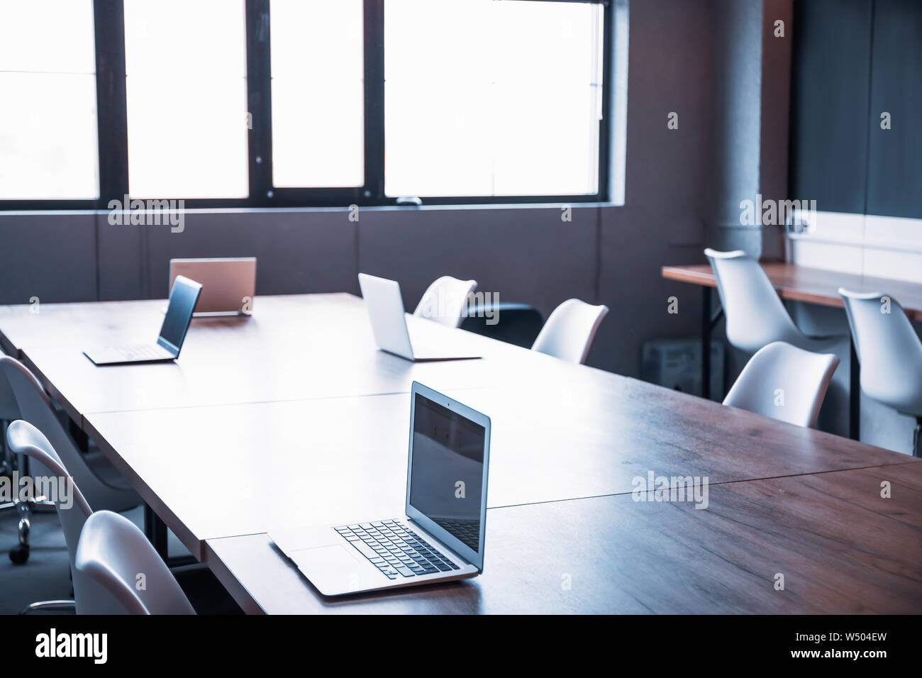 Big table with laptops prepared for business meeting in modern office ...