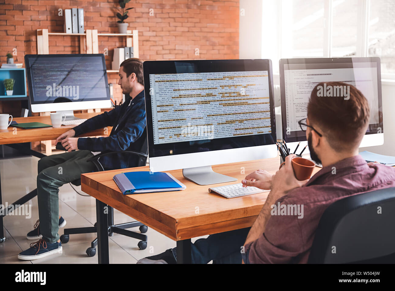 Team of programmers working in office Stock Photo - Alamy