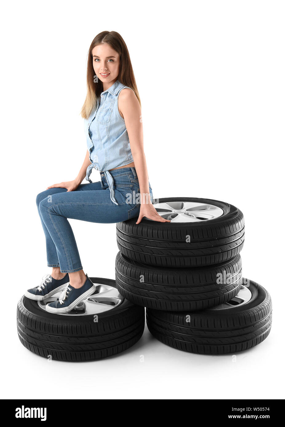 Young woman with car tires on white background Stock Photo - Alamy