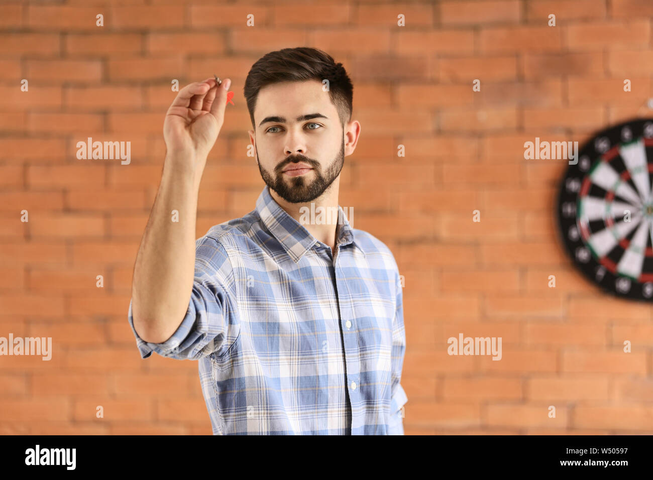 Young man playing darts indoors Stock Photo - Alamy