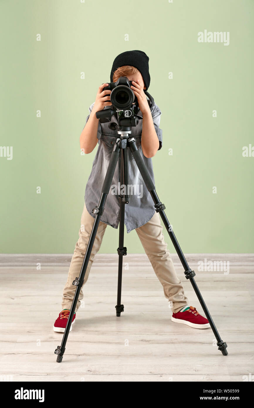 Cute little photographer with professional camera indoors Stock Photo ...