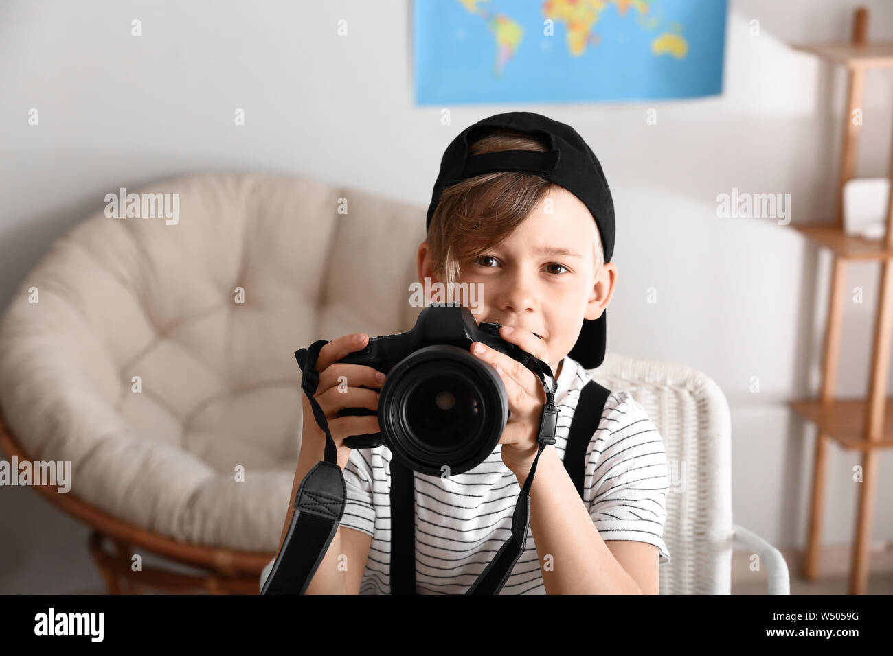 Cute little photographer with professional camera at home Stock Photo ...
