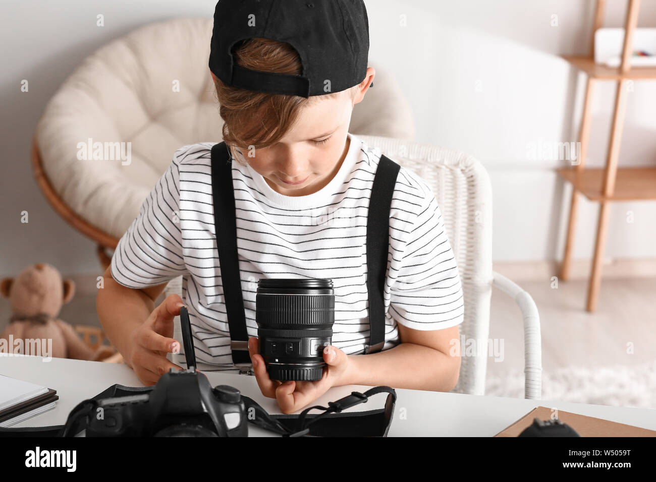 Cute little photographer with professional camera at home Stock Photo ...