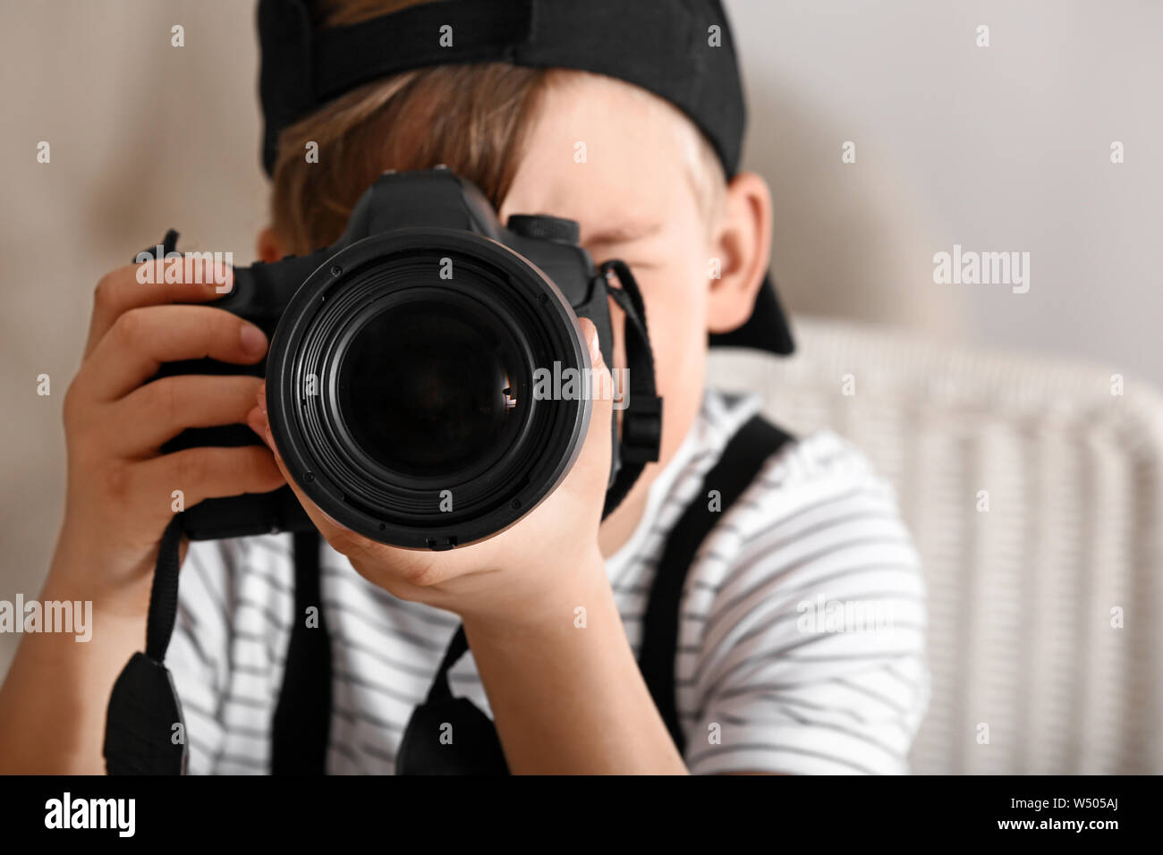Cute little photographer with professional camera at home Stock Photo ...