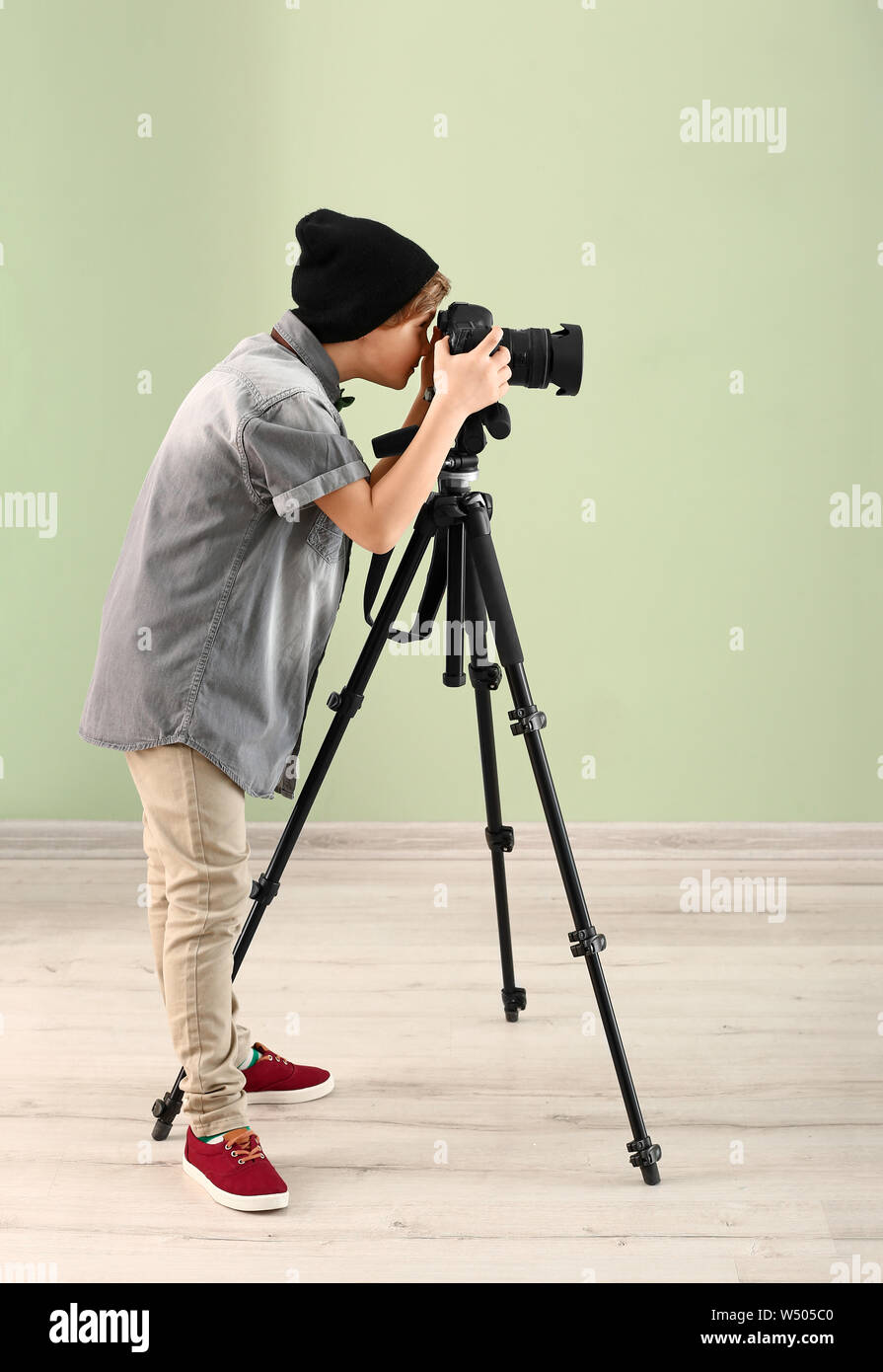 Cute little photographer with professional camera indoors Stock Photo ...