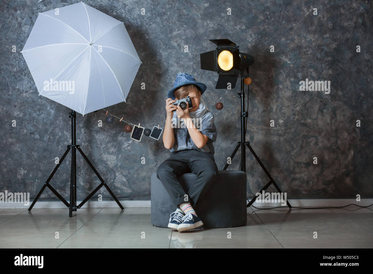 Cute little photographer with camera in professional studio Stock Photo ...