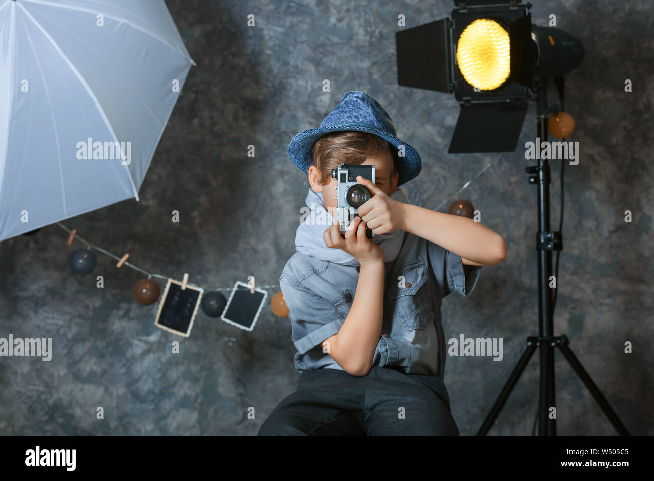 Cute little photographer with camera in professional studio Stock Photo ...