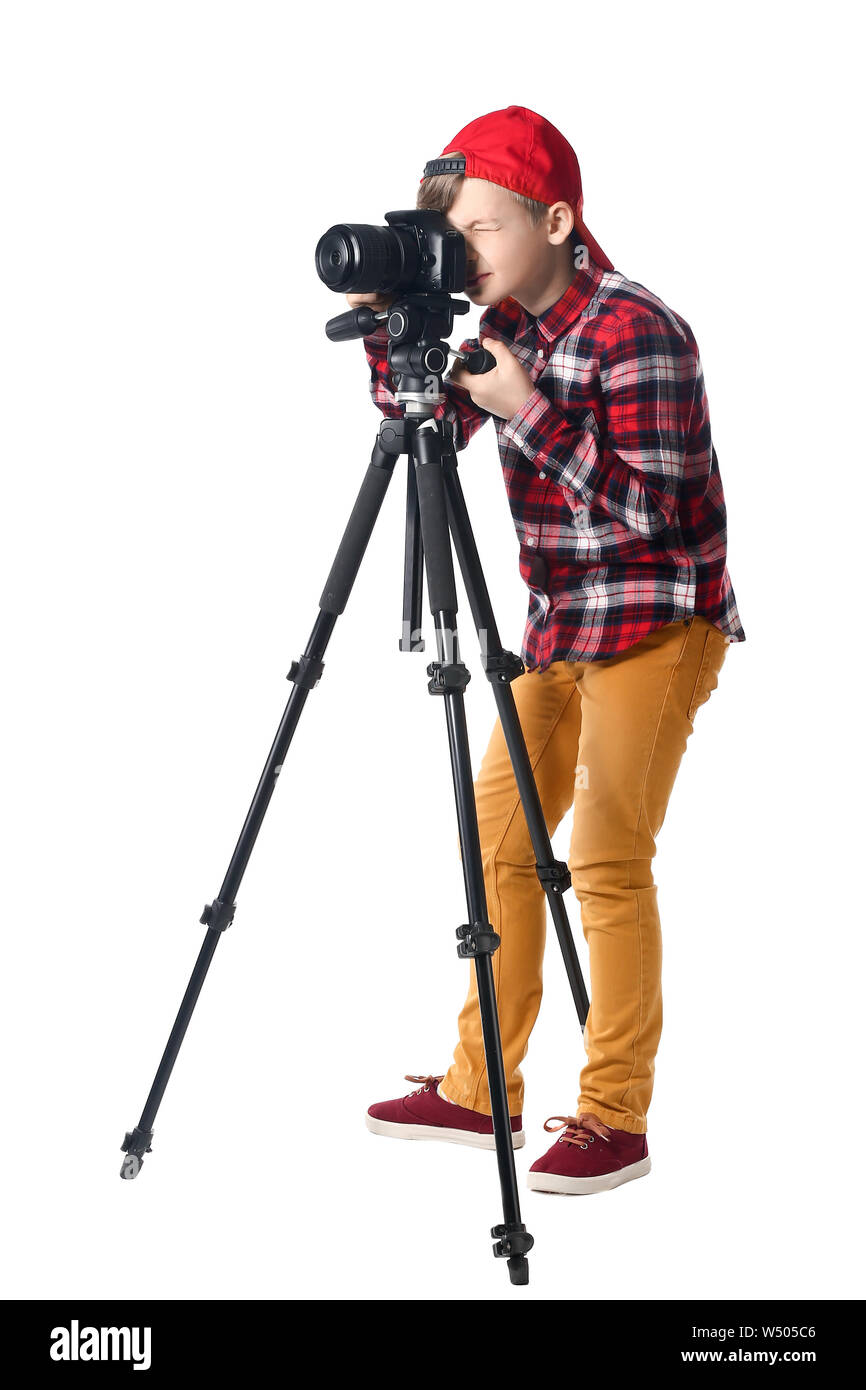 Cute little photographer with professional camera on white background ...