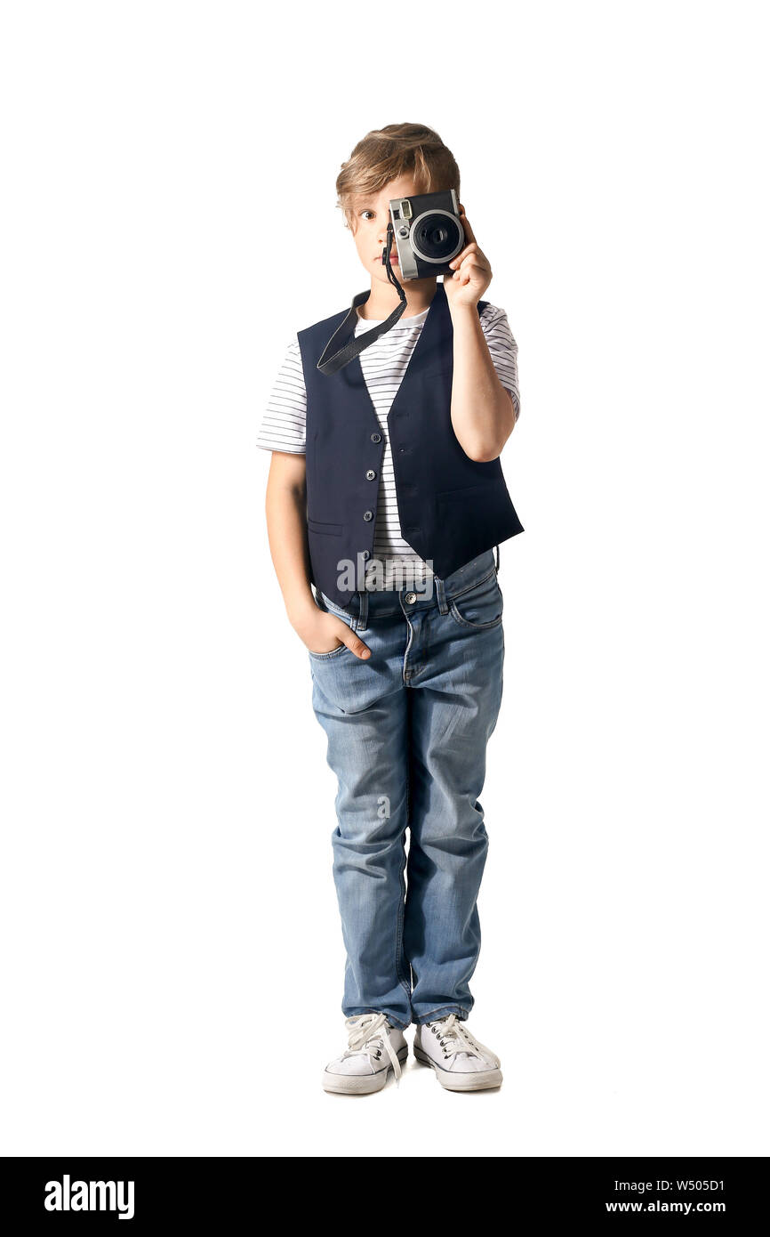Cute little photographer with professional camera on white background ...