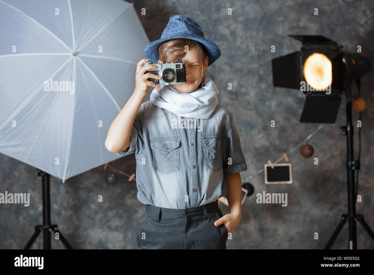 Cute little photographer with camera in professional studio Stock Photo ...