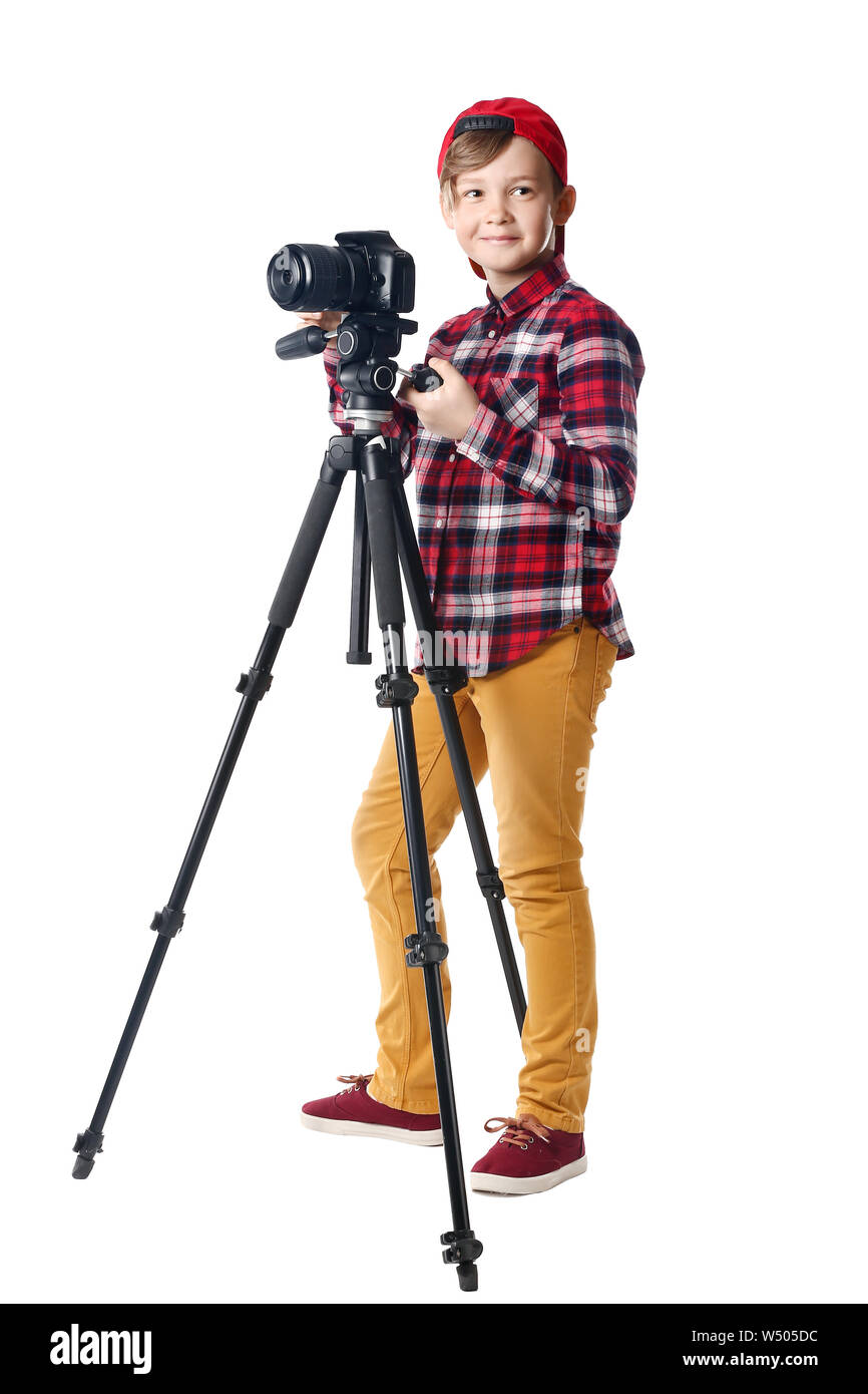 Cute little photographer with professional camera on white background ...