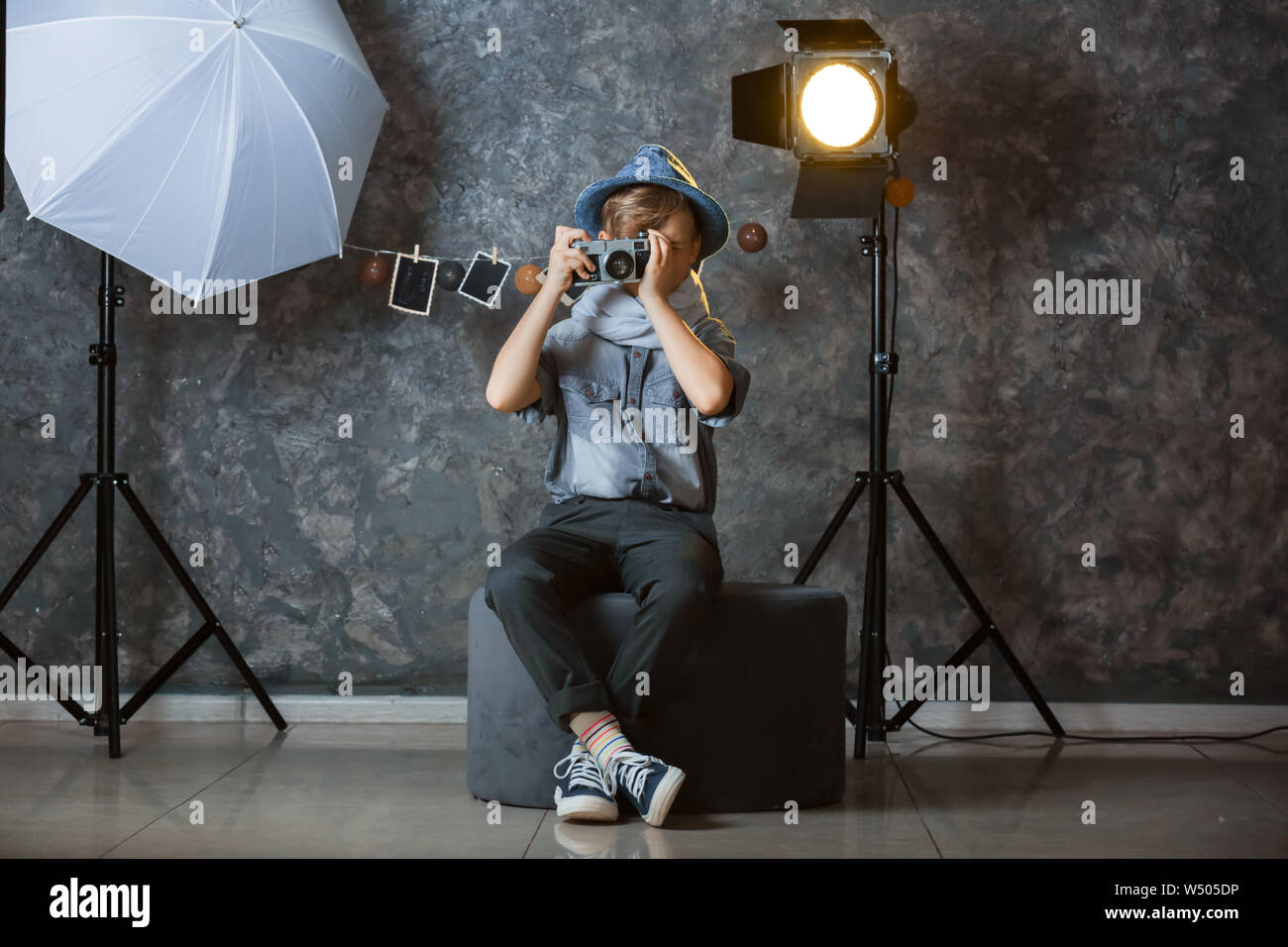 Cute little photographer with camera in professional studio Stock Photo ...
