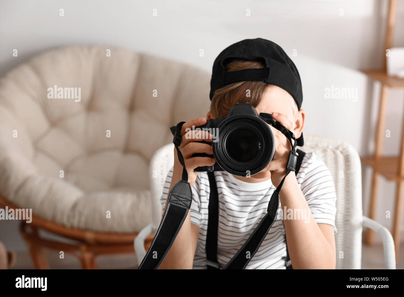 Cute little photographer with professional camera at home Stock Photo ...