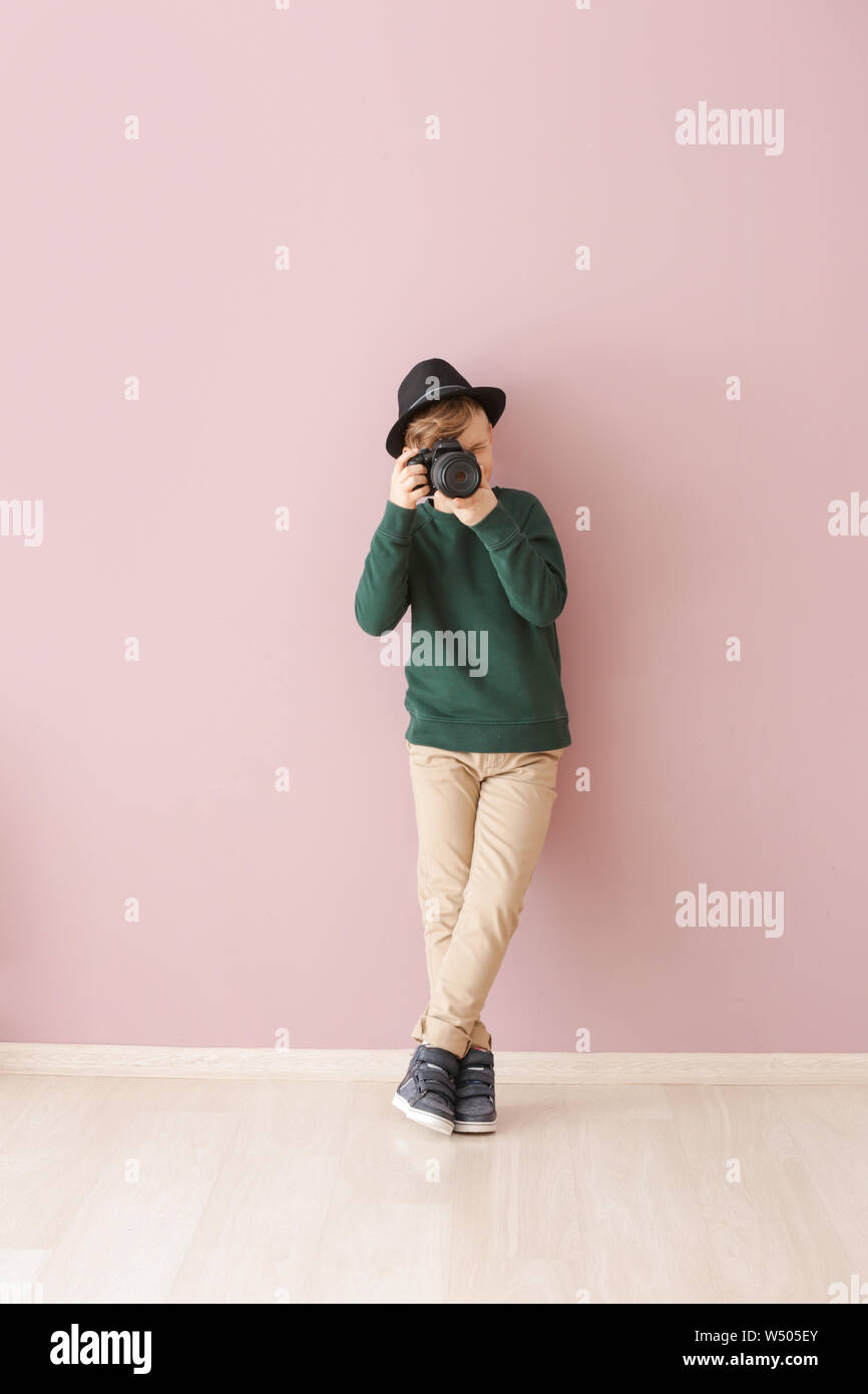 Cute little photographer with professional camera near color wall Stock ...