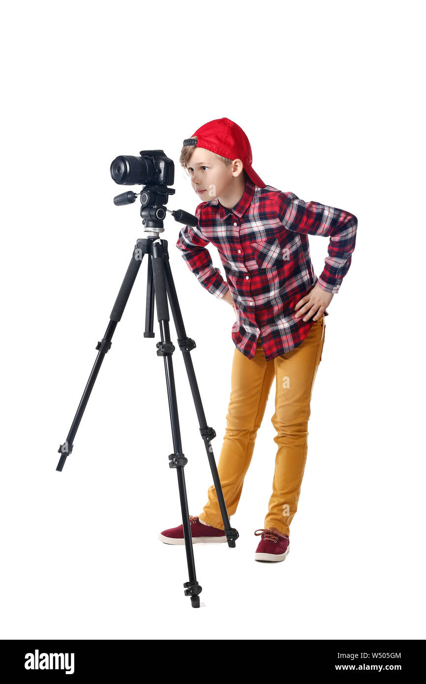 Cute little photographer with professional camera on white background ...