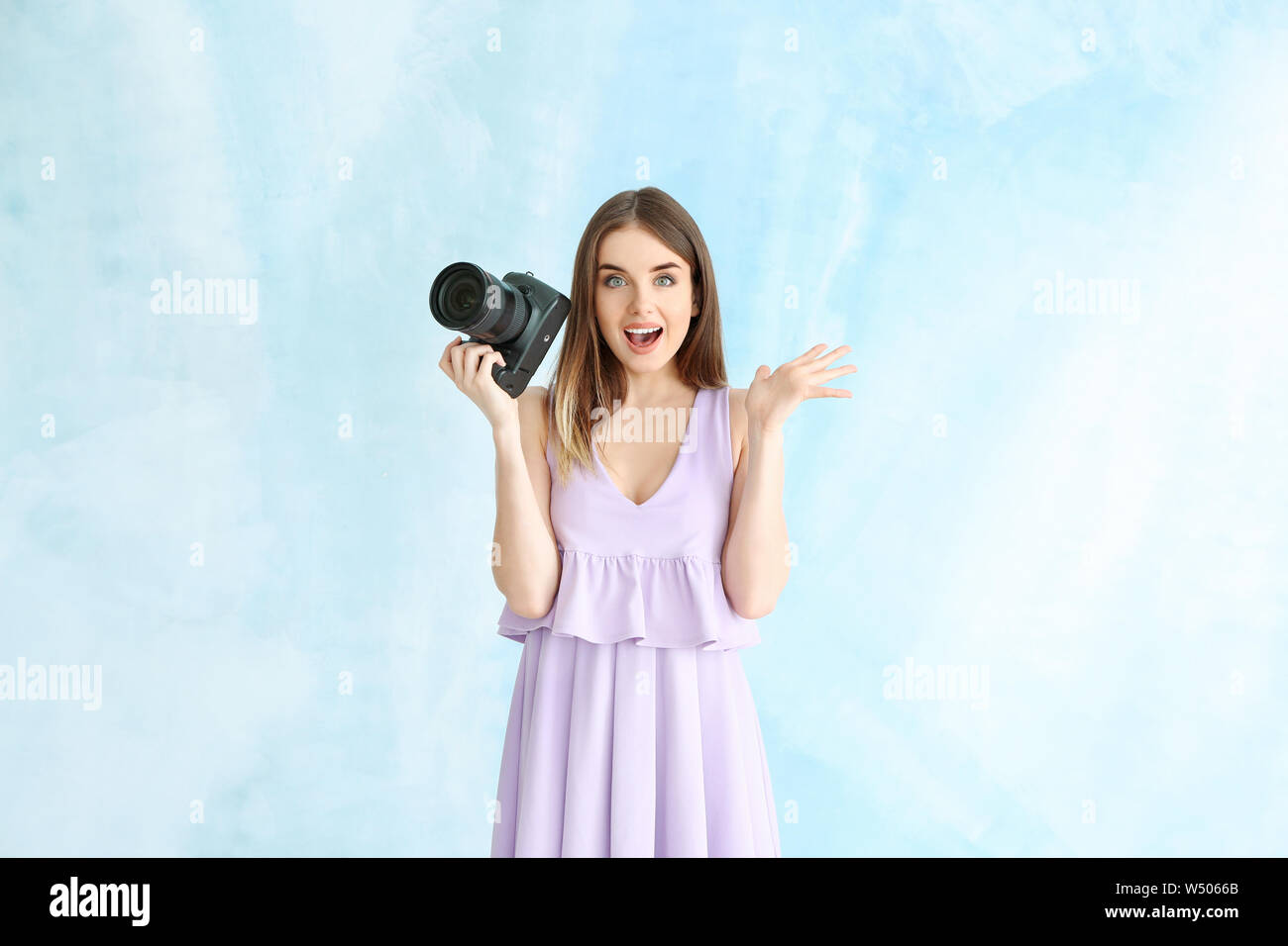 Excited female photographer on color background Stock Photo - Alamy