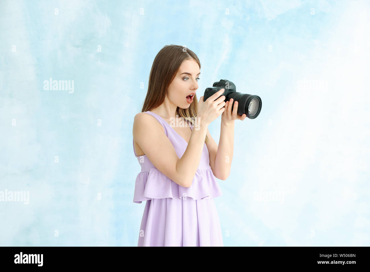 Shocked female photographer on color background Stock Photo - Alamy