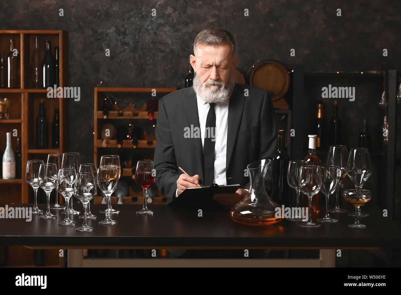 Mature sommelier working in wine cellar Stock Photo - Alamy