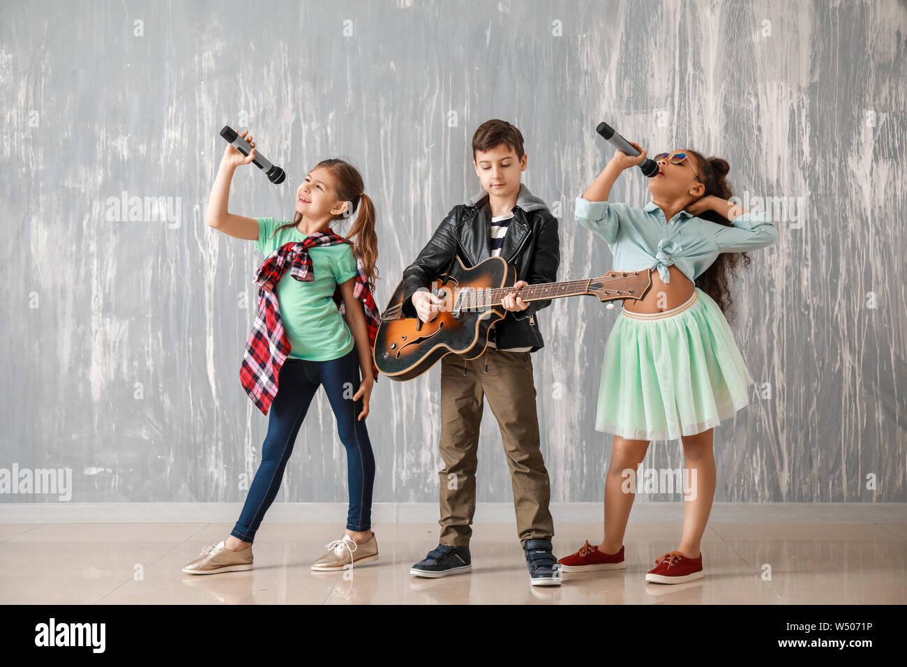 Band of little musicians against grunge wall Stock Photo - Alamy