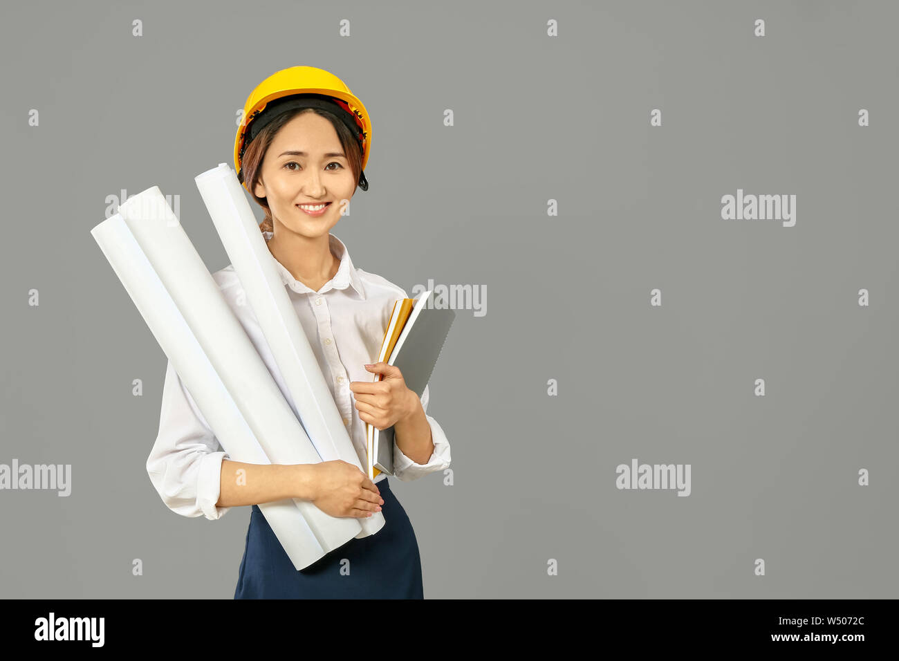 Female Asian engineer on grey background Stock Photo - Alamy