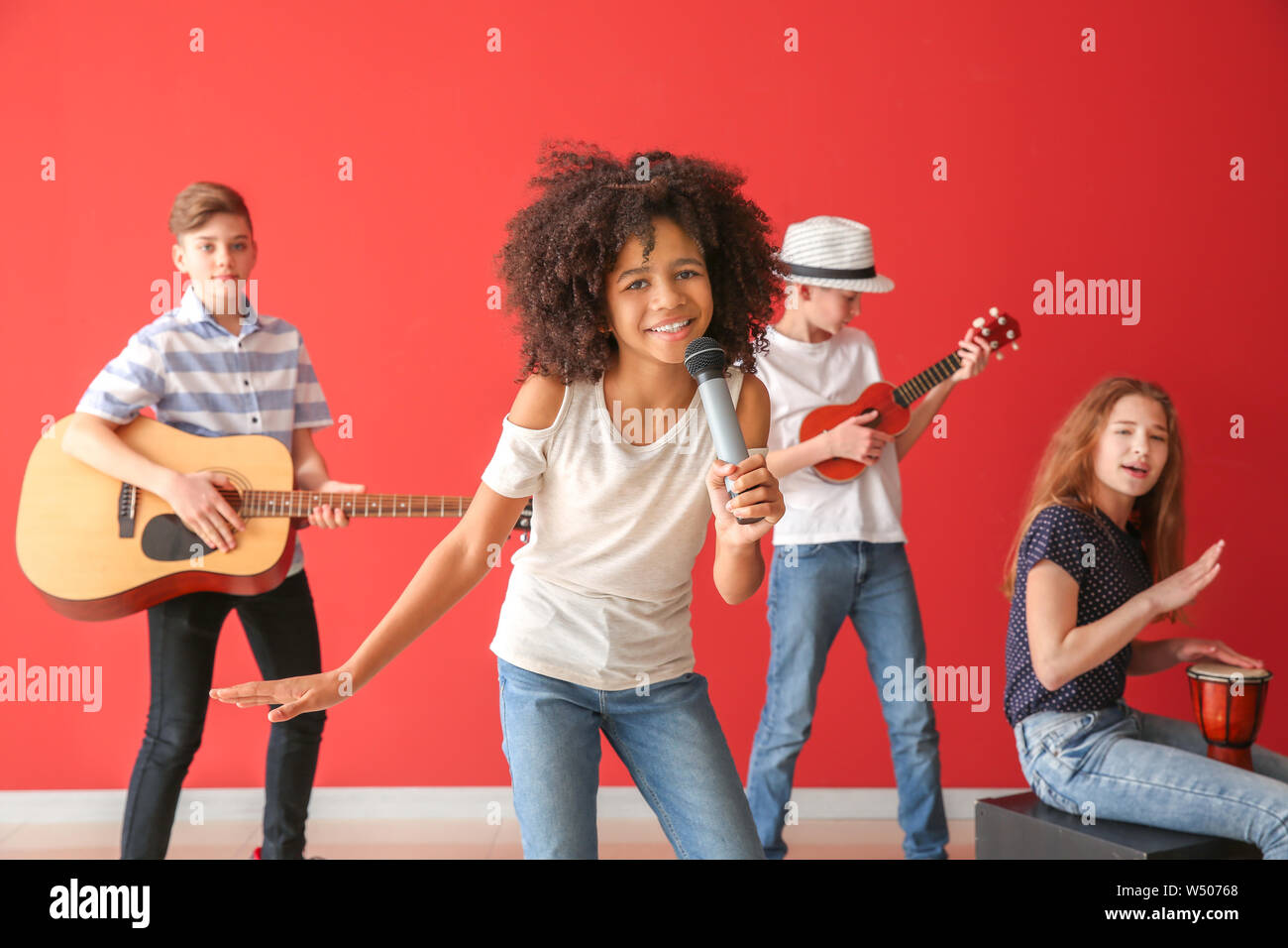 Teenage musicians playing against color wall Stock Photo - Alamy