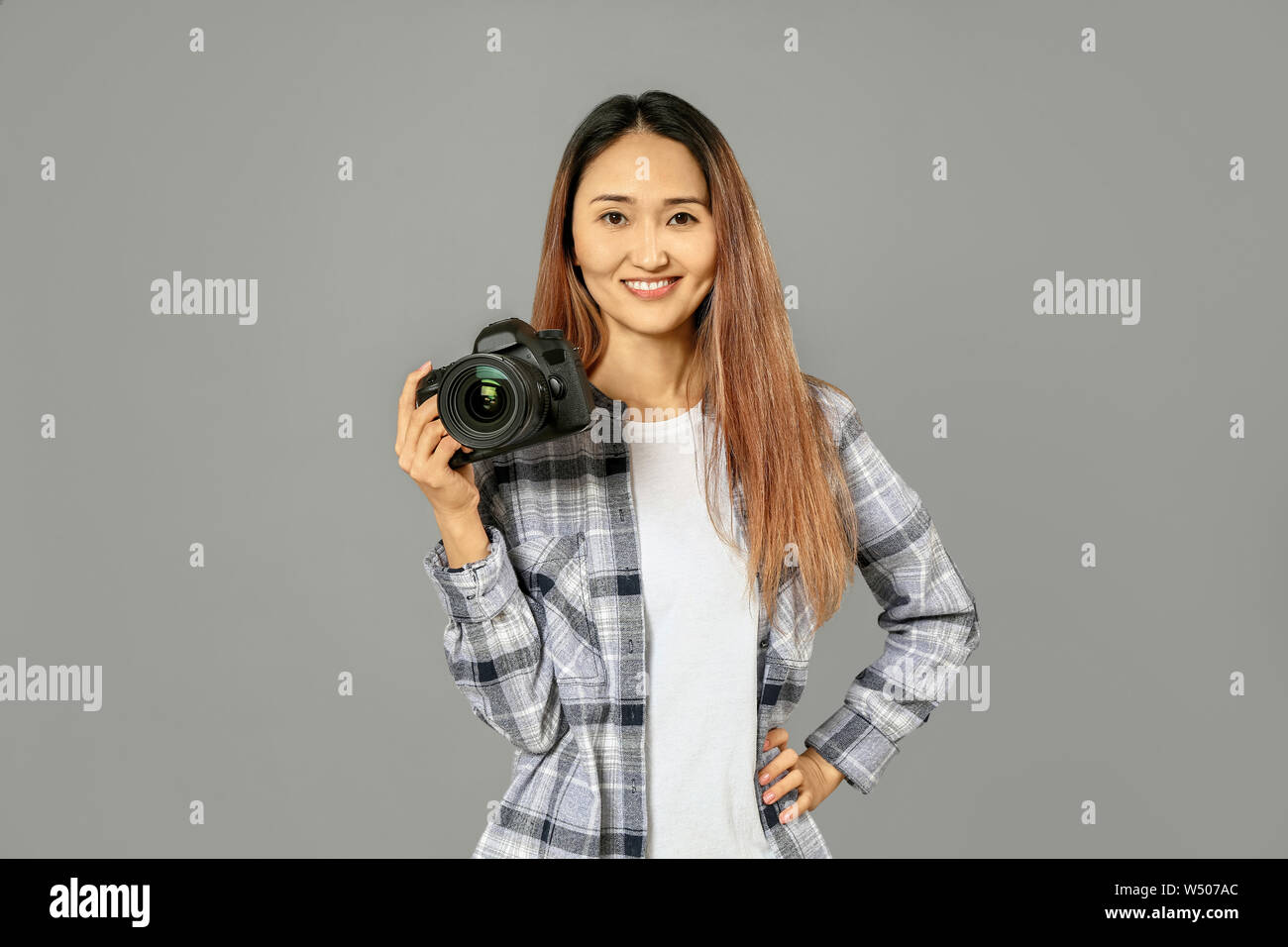 Female Asian photographer on grey background Stock Photo - Alamy