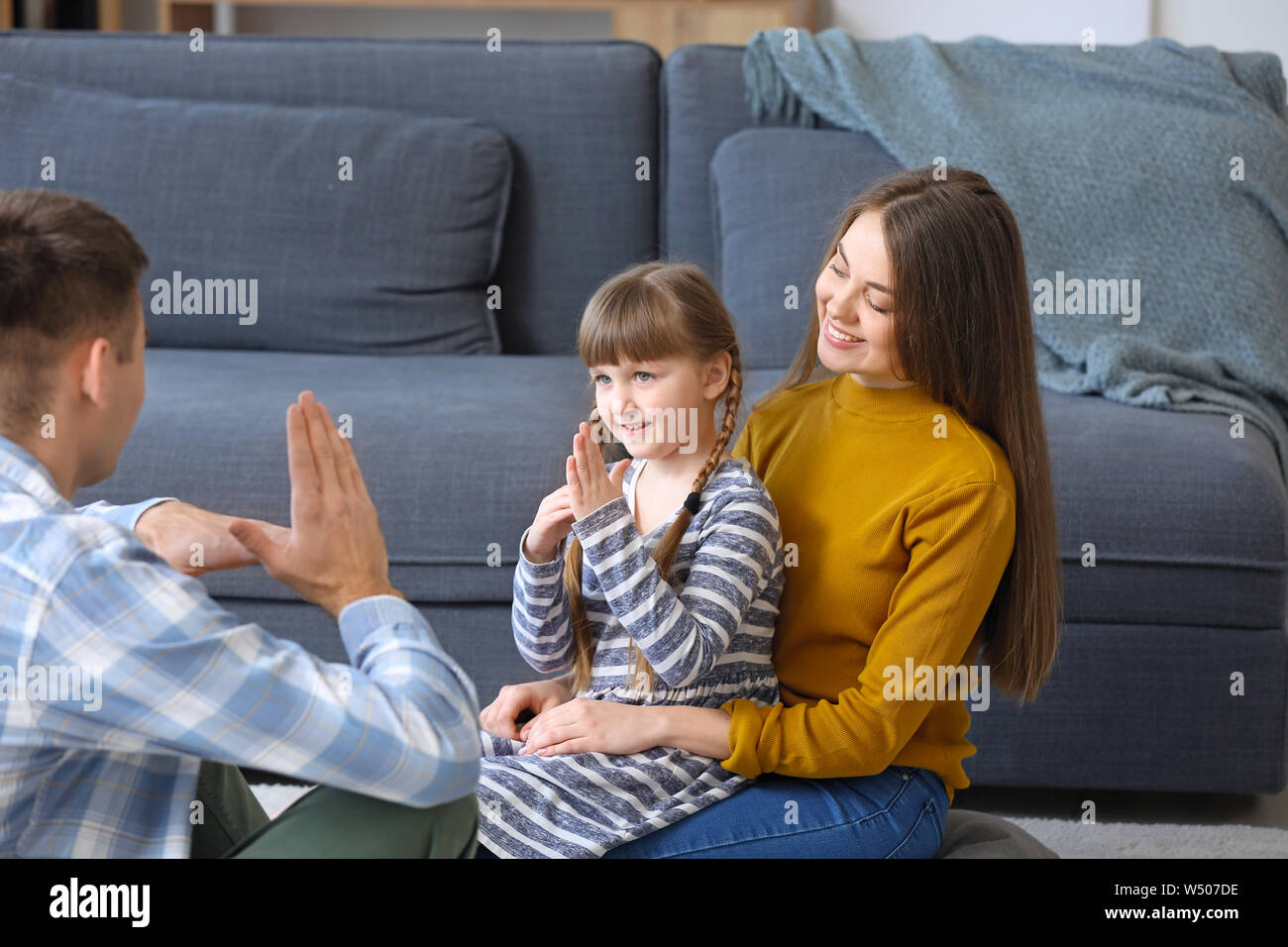Deaf mute family using sign language at home Stock Photo - Alamy