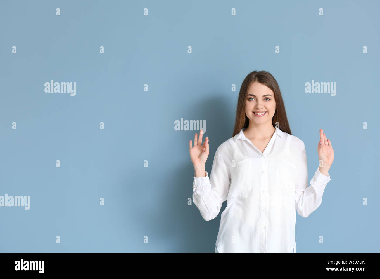Young deaf mute woman using sign language on color background Stock ...