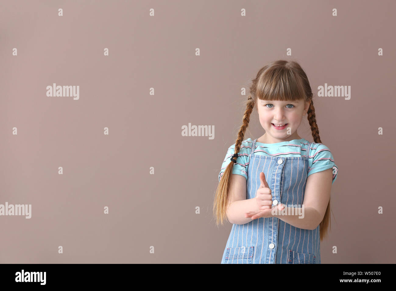 Cute deaf mute girl using sign language on color background Stock Photo ...