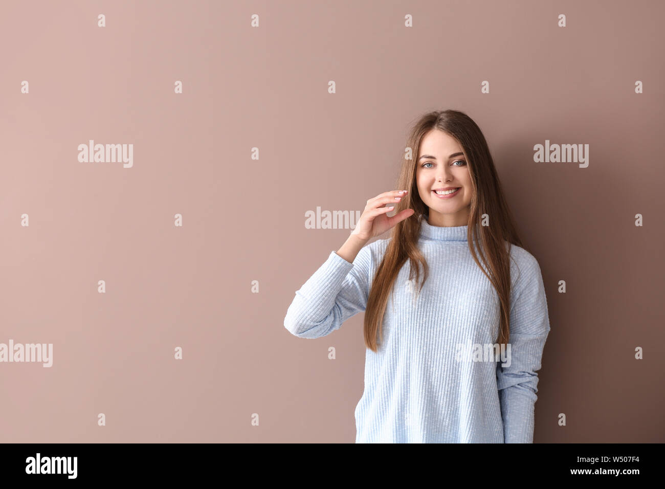 Young deaf mute woman using sign language on color background Stock ...