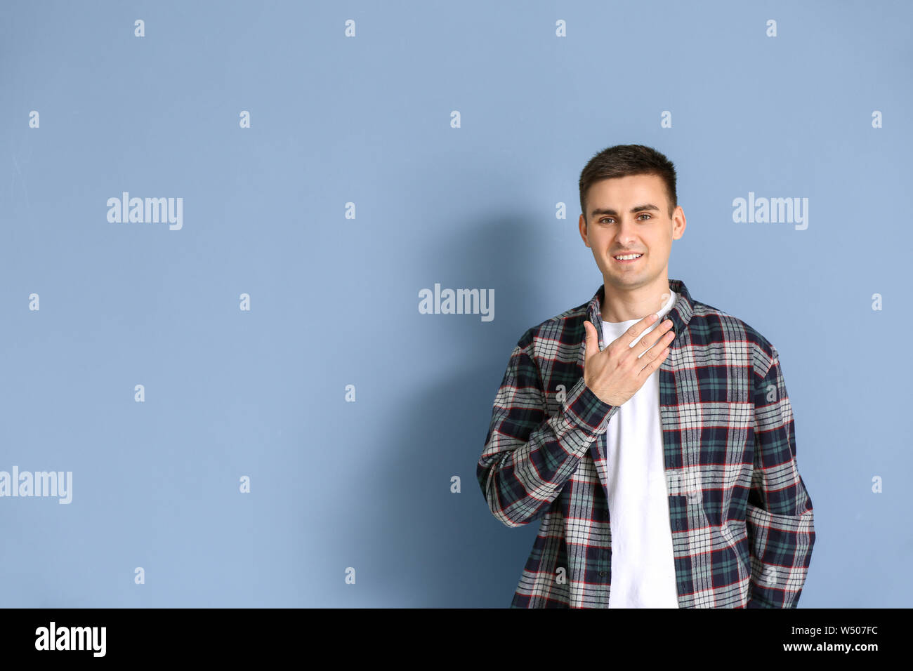 Young deaf mute man using sign language on grey background Stock Photo ...