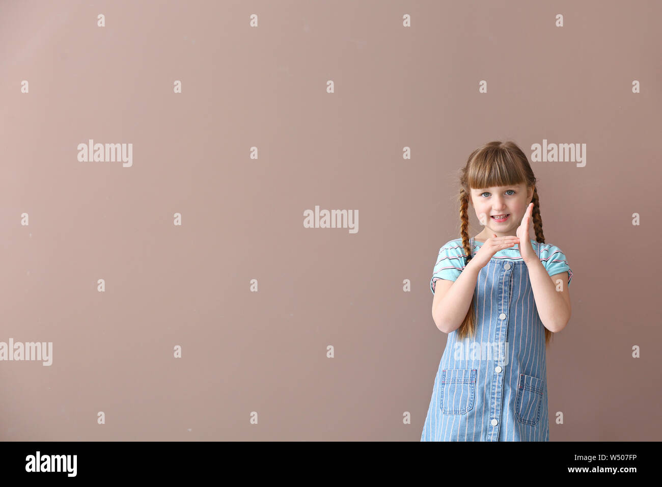 Cute deaf mute girl using sign language on color background Stock Photo ...