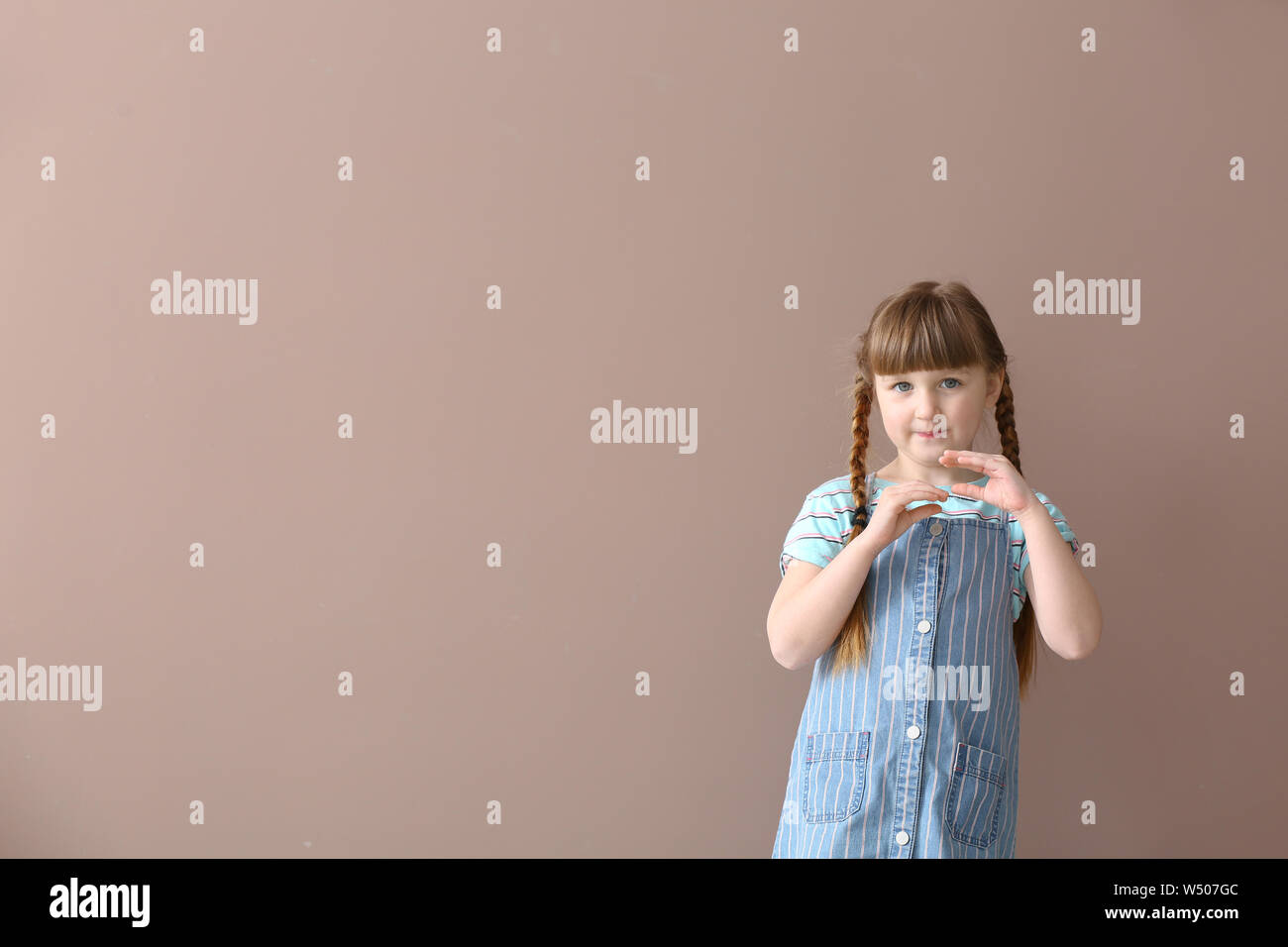 Cute deaf mute girl using sign language on color background Stock Photo ...