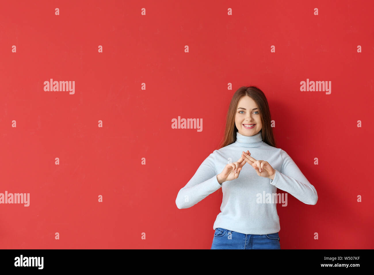 Young deaf mute woman using sign language on color background Stock ...