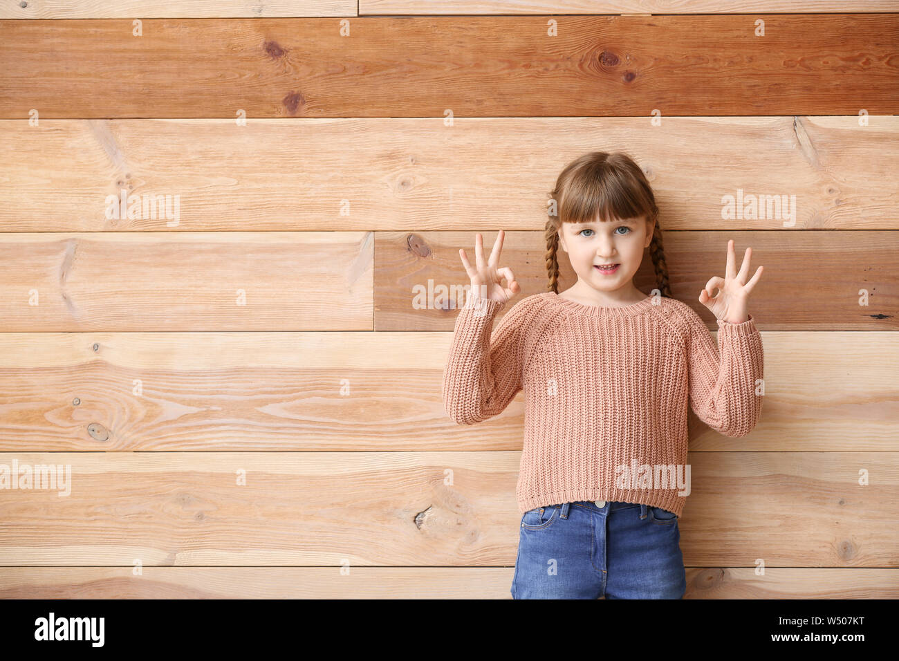 Cute deaf mute girl using sign language on wooden background Stock ...