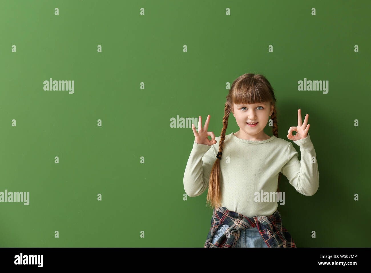 Cute deaf mute girl using sign language on color background Stock Photo ...