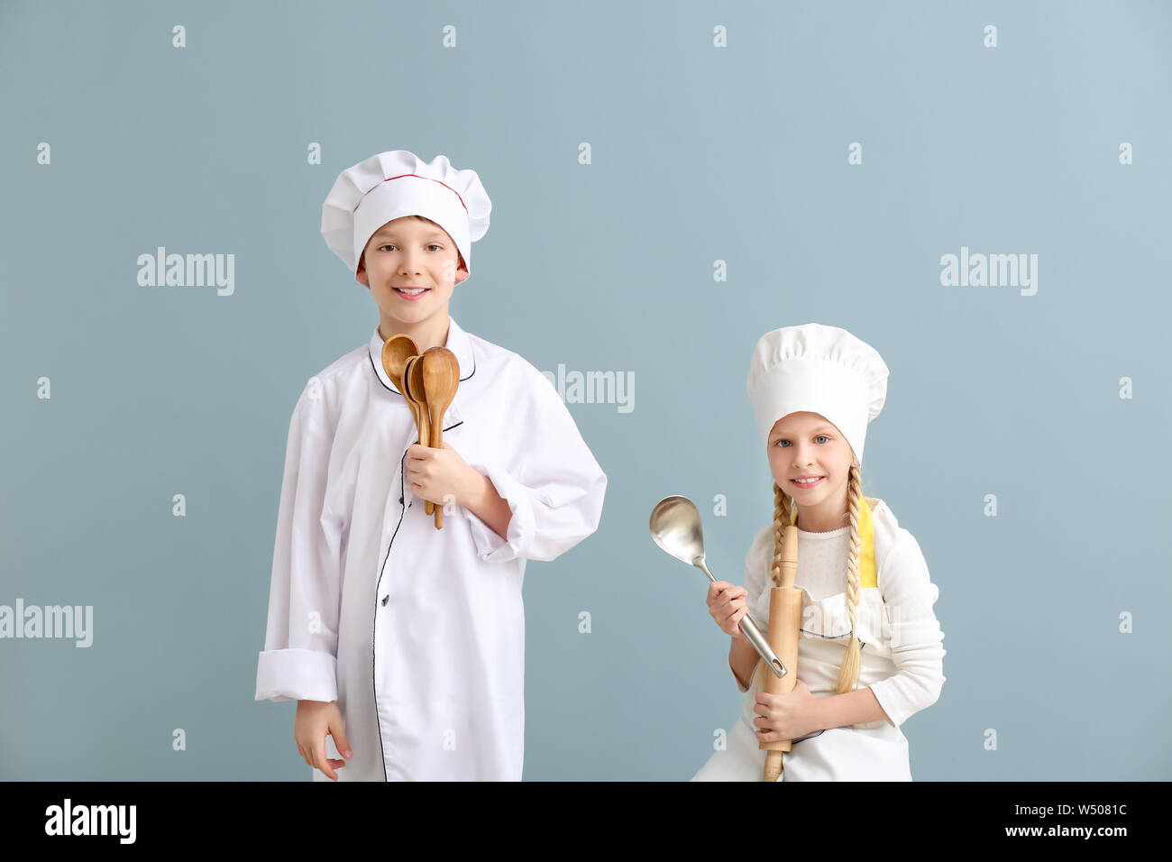 Cute little chefs on color background Stock Photo - Alamy
