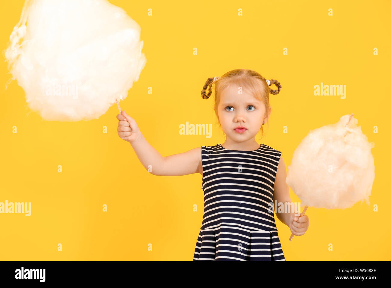 Cute little girl with cotton candy on color background Stock Photo - Alamy