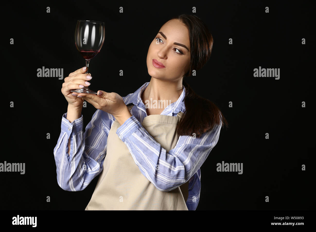 Portrait of elegant female sommelier on dark background Stock Photo - Alamy