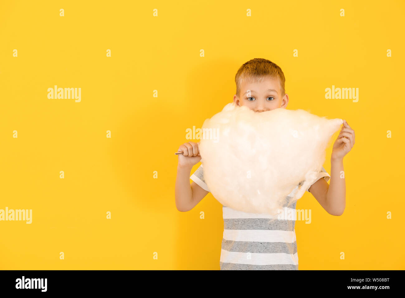 Cute little boy with cotton candy on color background Stock Photo - Alamy