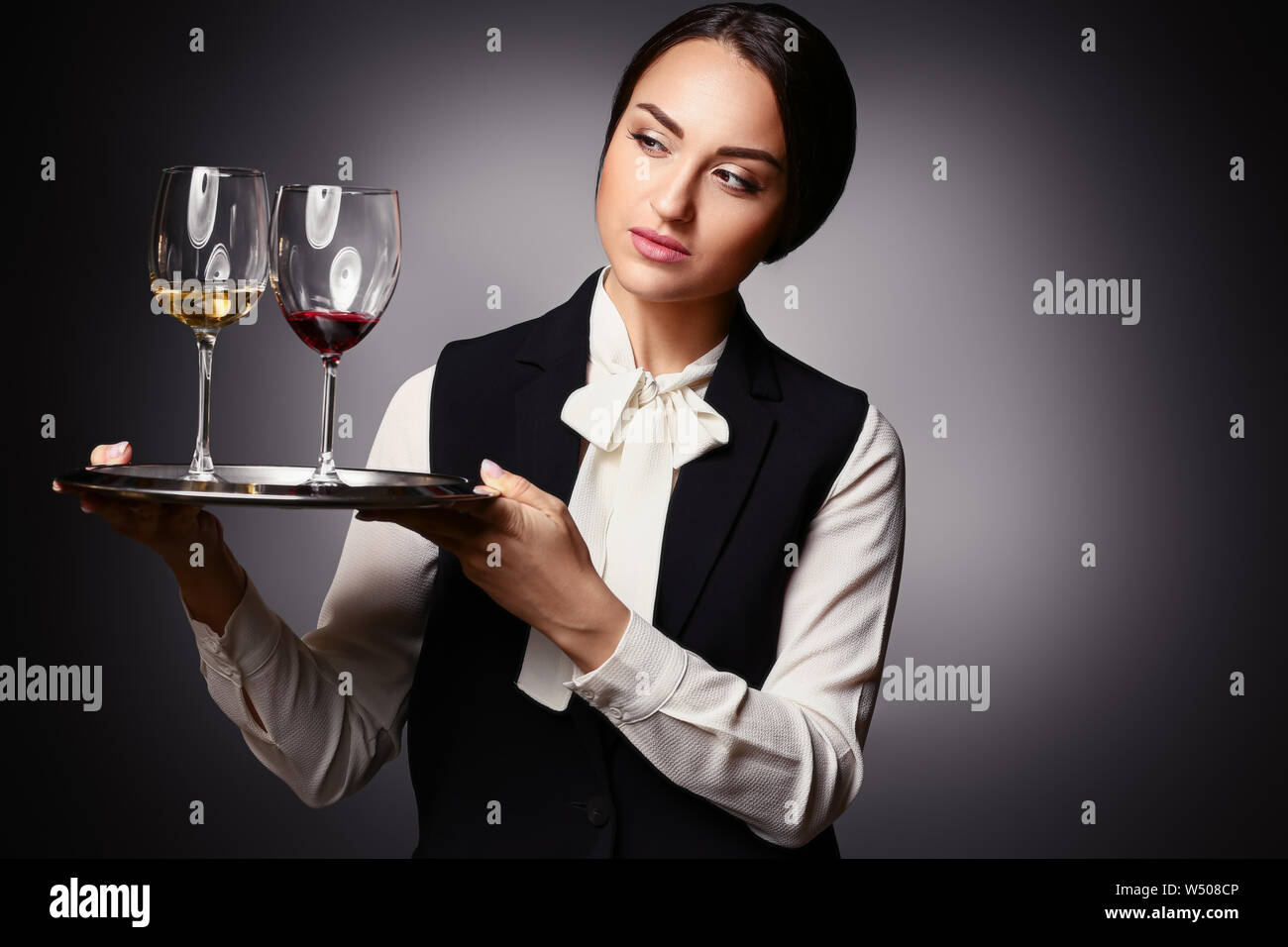 Portrait of elegant female sommelier on dark background Stock Photo - Alamy