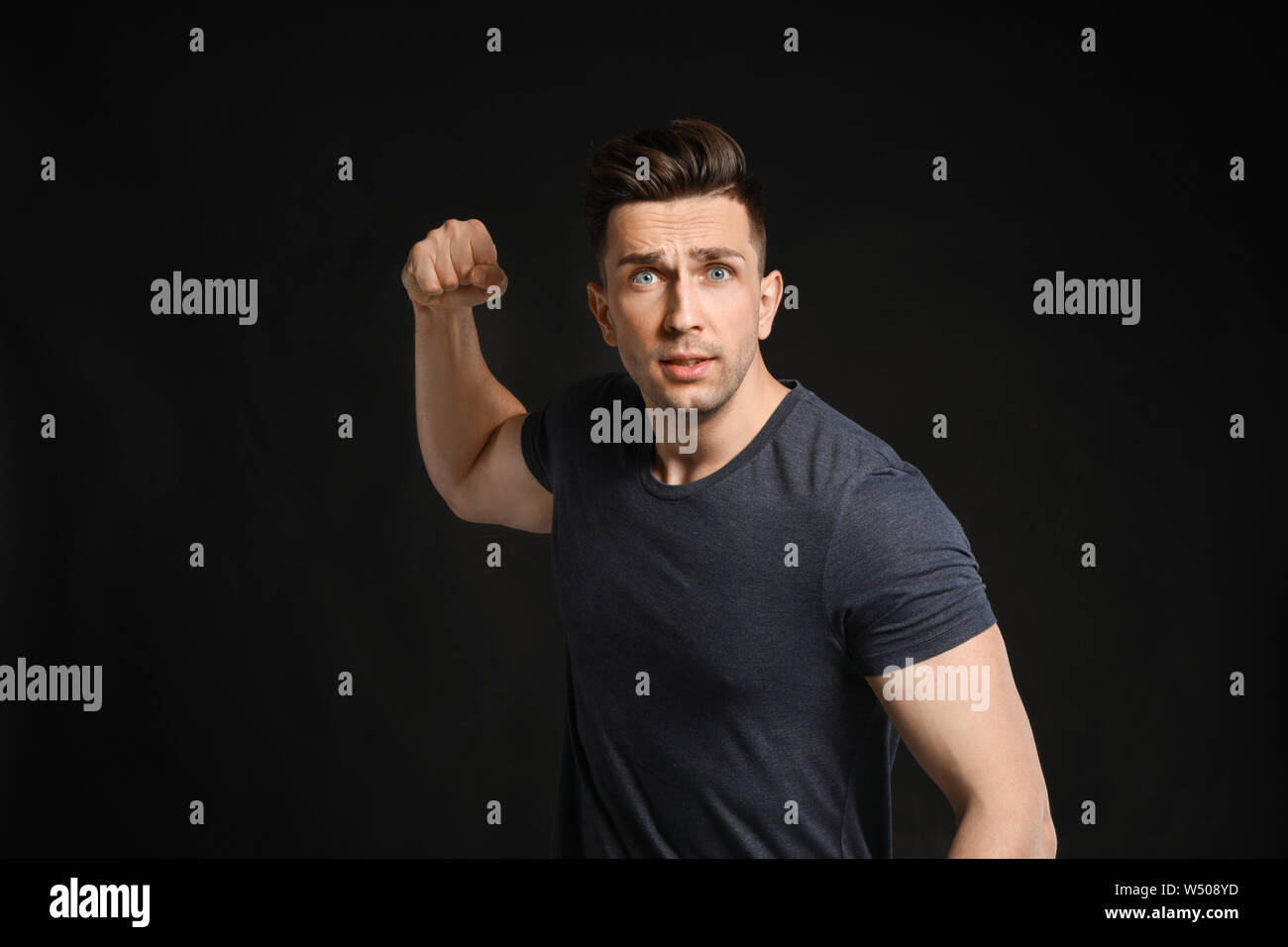 Aggressive young man on dark background Stock Photo - Alamy