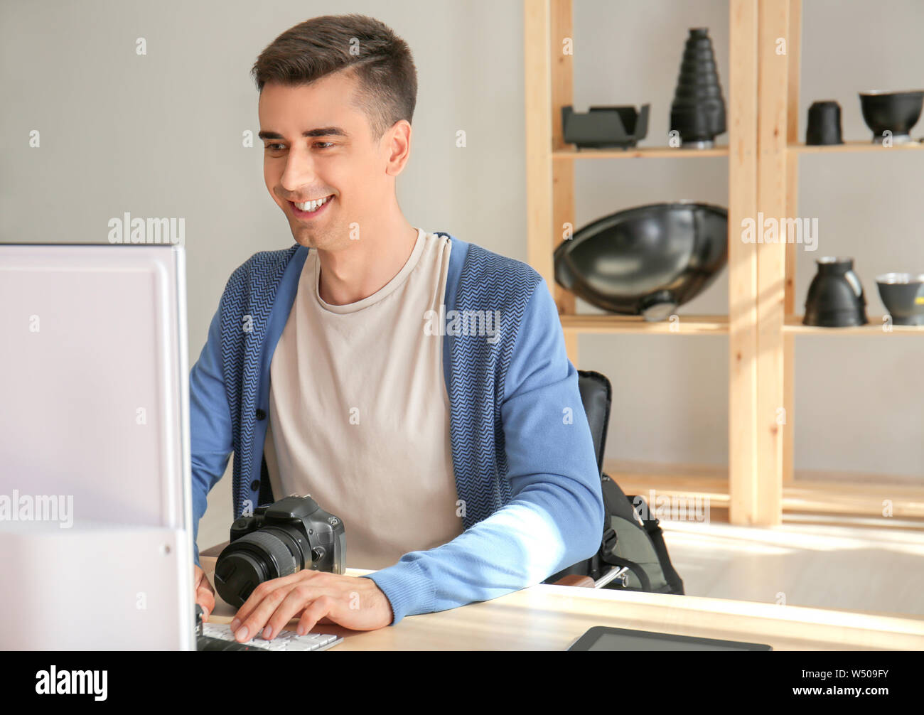 Male photographer working on computer in studio Stock Photo - Alamy