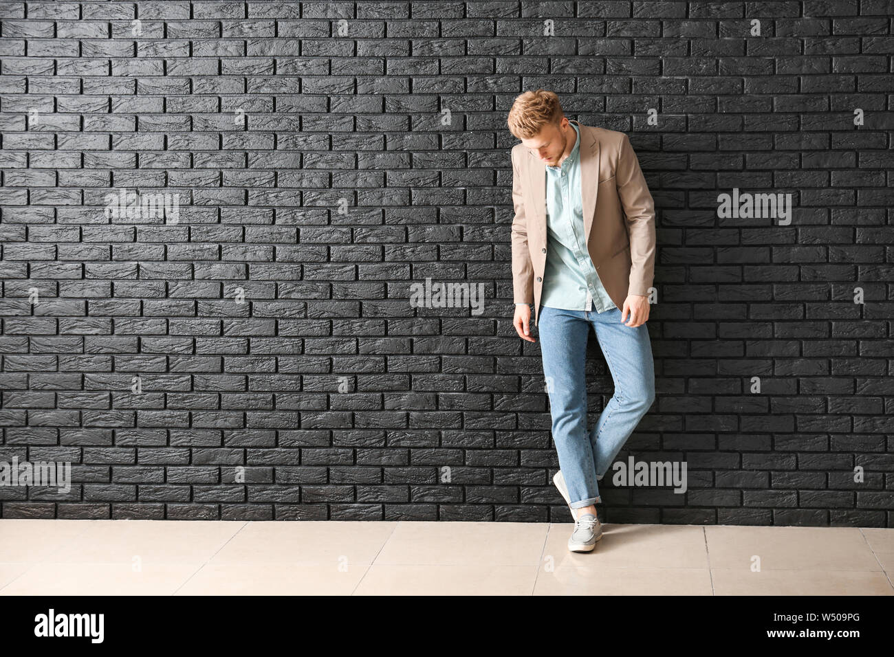 Young guy standing near brick hi-res stock photography and images - Alamy