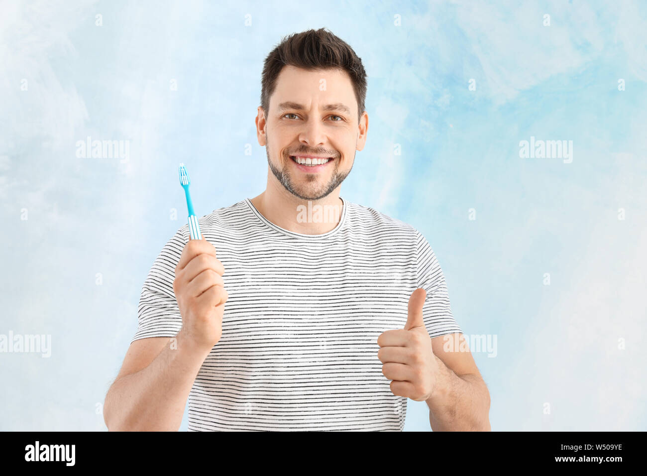 Man with toothbrush on light background Stock Photo - Alamy