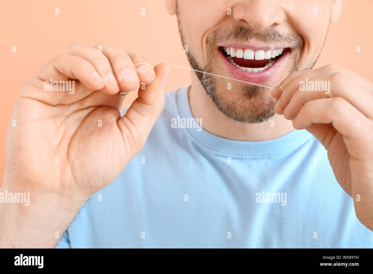 Man flossing teeth on color background, closeup Stock Photo - Alamy