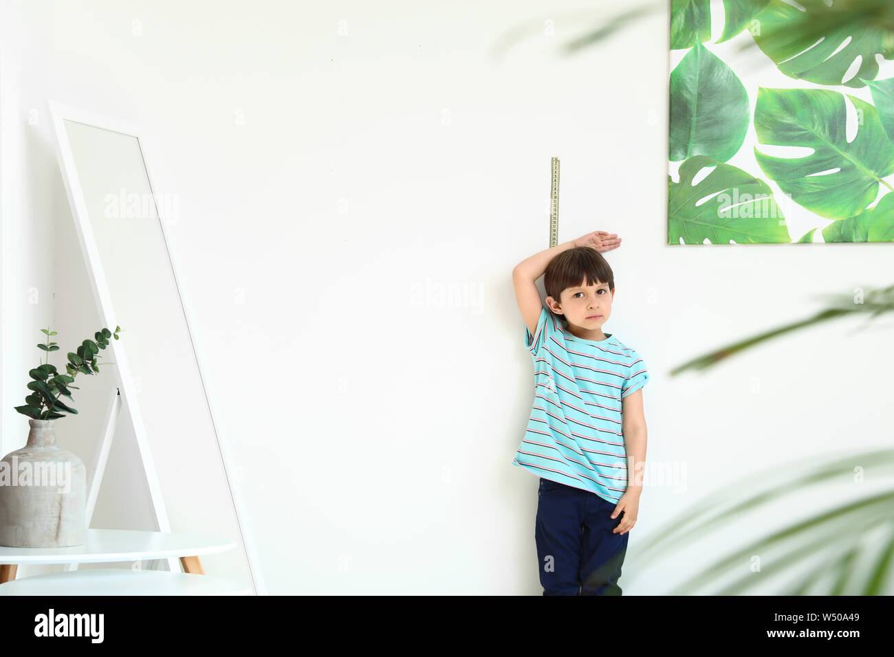 Cute little boy measuring height near wall Stock Photo - Alamy