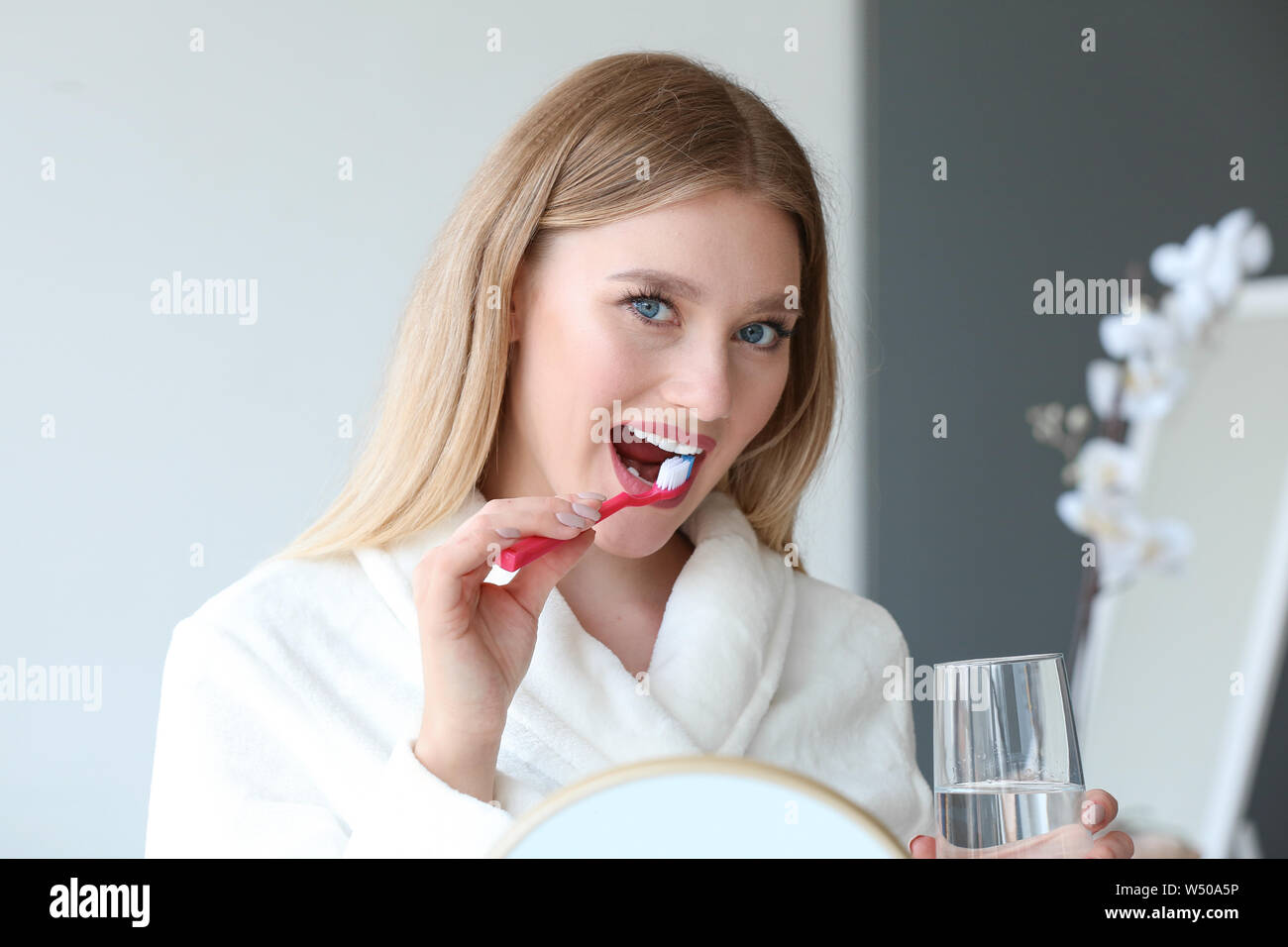 Beautiful woman cleaning teeth at home Stock Photo - Alamy